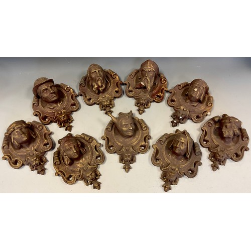Set of nine gilt and burgundy character mask plaques each as a ...