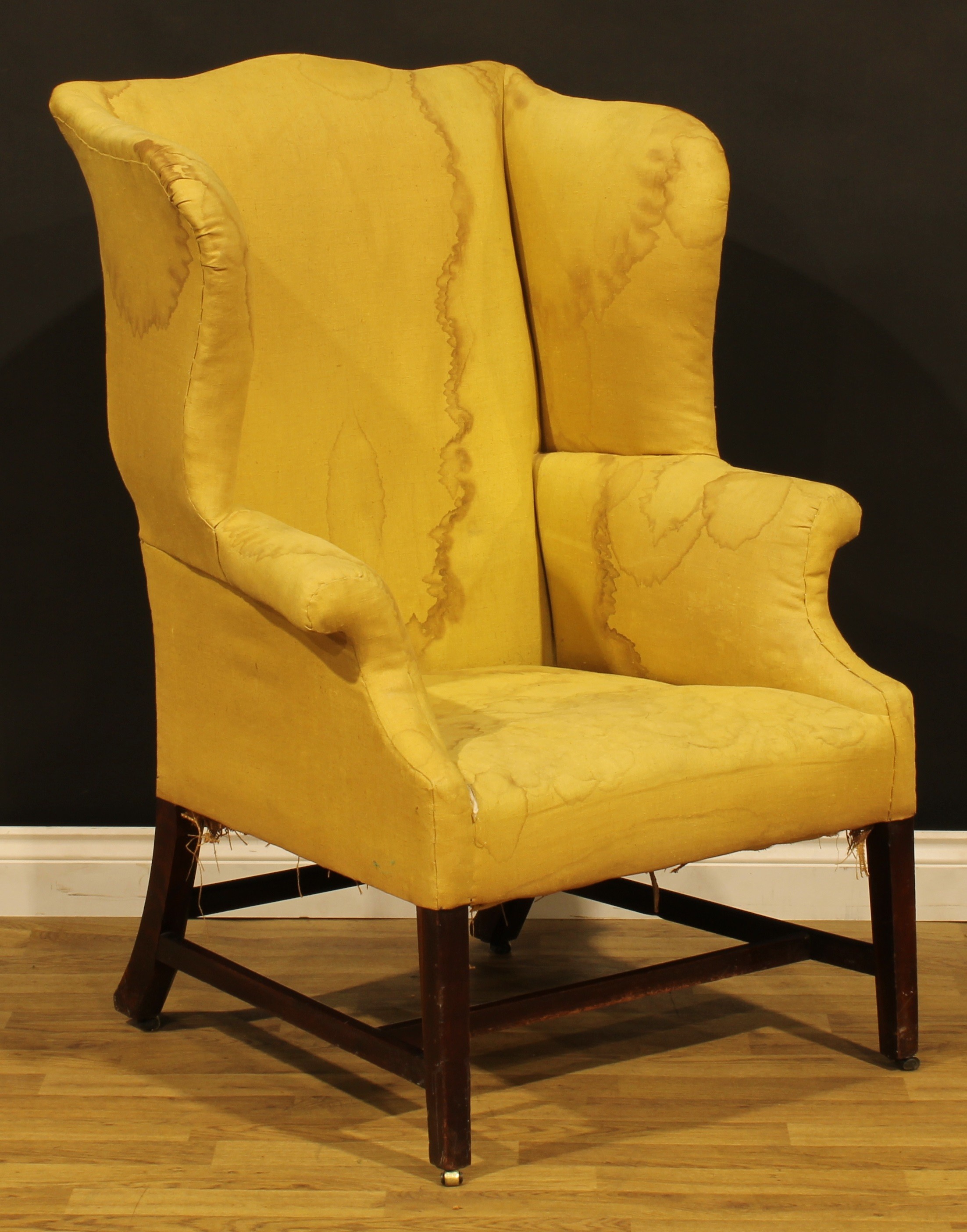 A George III wing chair, stuffed-over upholstery, tapered square ...