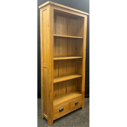 An oak tall open bookcase, four tiers of shelving, above a pair of ...