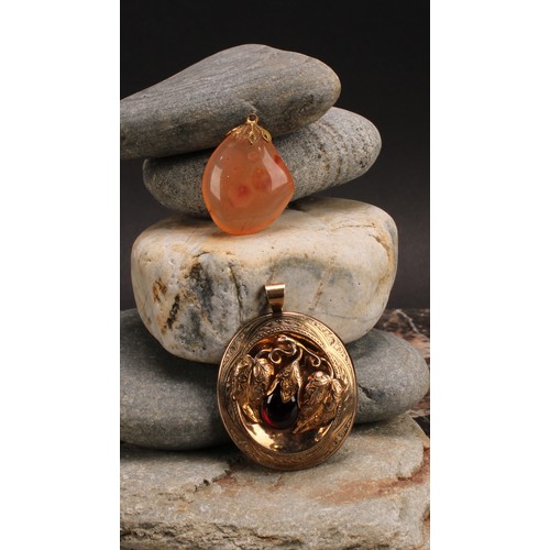 A Victorian gold coloured metal oval pendant, engraved with scrolls and ...