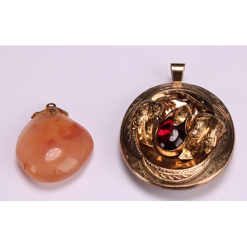 A Victorian gold coloured metal oval pendant, engraved with scrolls and ...