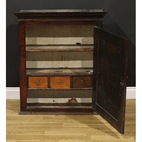 A George III oak wall hanging provision cupboard, raised and fielded ...