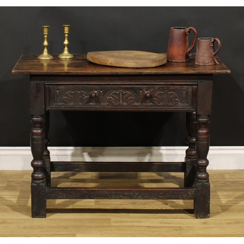 A 17th century oak side table, oversailing top above a long frieze ...
