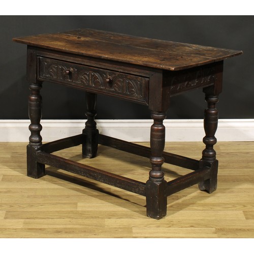 A 17th century oak side table, oversailing top above a long frieze ...