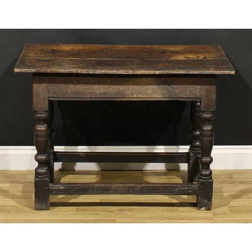 A 17th century oak side table, oversailing top above a long frieze ...