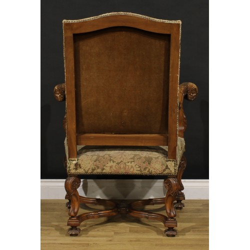 A Baroque walnut armchair, outswept arms boldly carved with acanthus ...