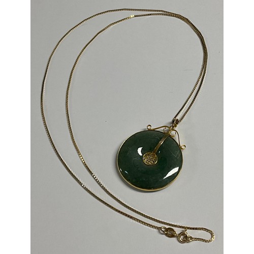A Chinese 14ct gold mounted green jade circular amulet pendant ...