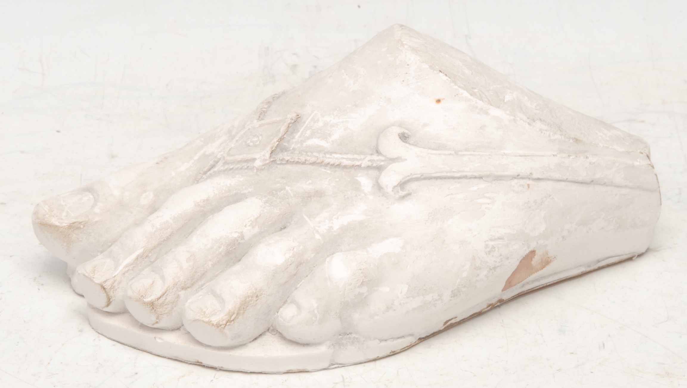 A museum type plaster cast, of a foot wearing a sandal, afte ...