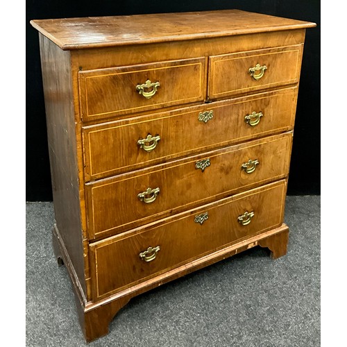 A George II walnut chest, crossbanded oversailing top above two short ...