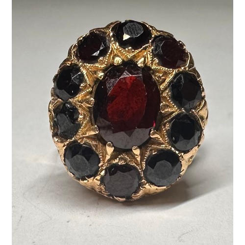 An 18ct gold almandine-pyrope garnet cluster ring, set with an oval ...