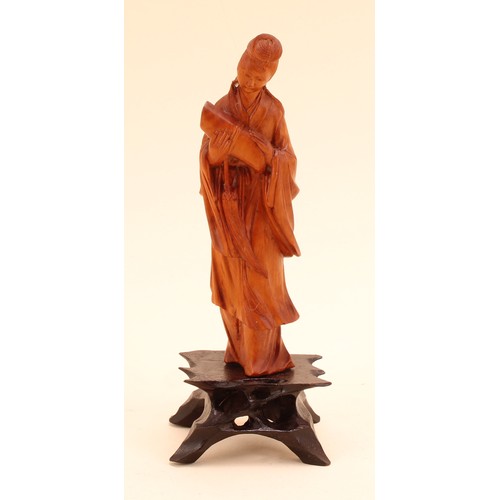 A Japanese hardwood figure on stand, carved as a Geisha, she stands ...