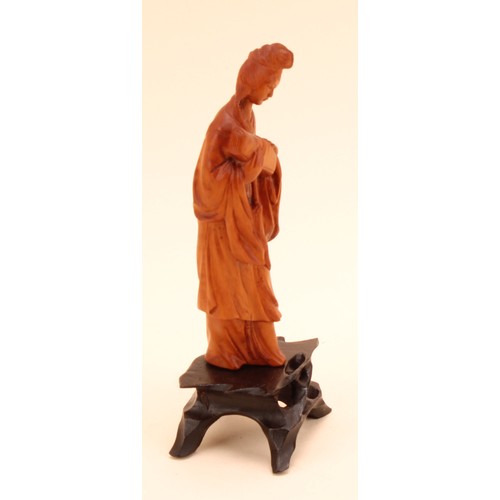 A Japanese hardwood figure on stand, carved as a Geisha, she stands ...