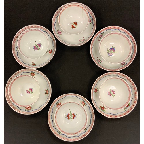 A group of Newhall tea bowls and saucers, painted with a decorative red ...