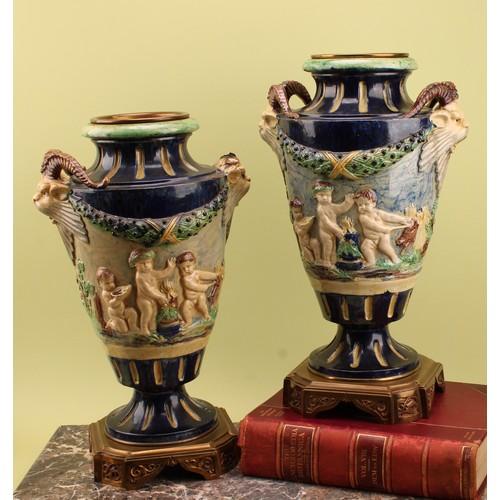 A pair of continental majolica vases or lamp bases, each with a pair of ...