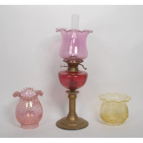 A brass and ruby glass oil/paraffin lamp, pink glass frill top shade ...