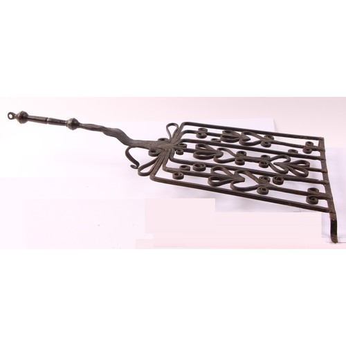 An Arts & Crafts wrought iron trivet, the rectangular plateau worked ...