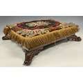 A Victorian rosewood footstool, stuffed over woolwork upholstery ...
