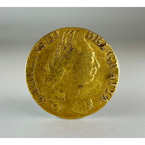 A 1782 George III gold guinea coin, on the obverse a laureate portrait ...