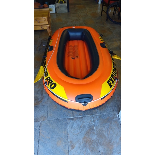 Inflatable boat, 'Explorer Pro' model, with two yellow paddles. Bright ...