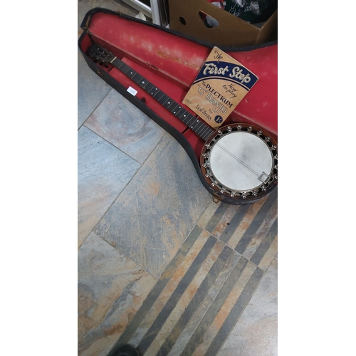 Four-string plectrum banjo with metal rim and wooden resonator, in red ...