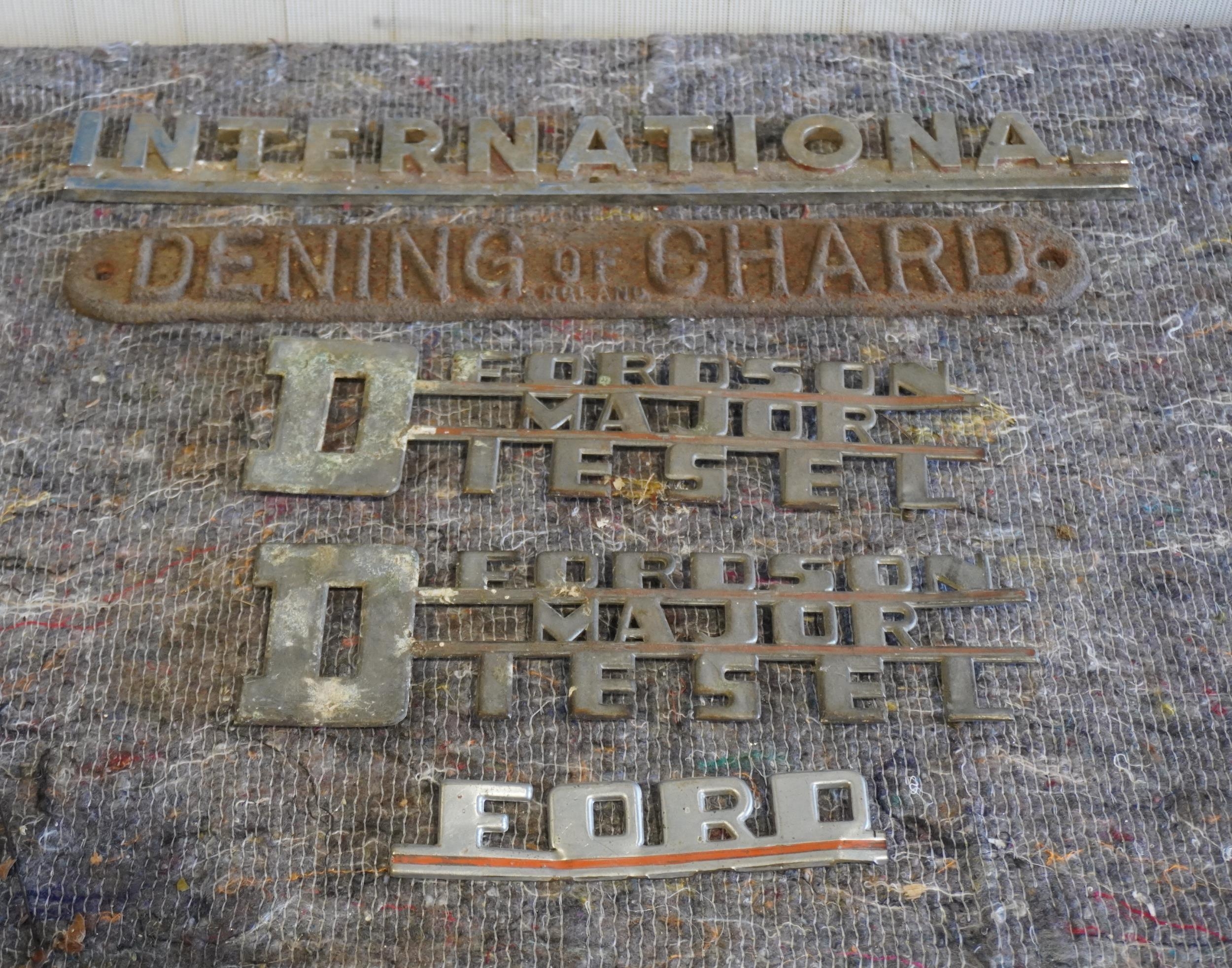 Assorted tractor name badges including International and Fordson Major