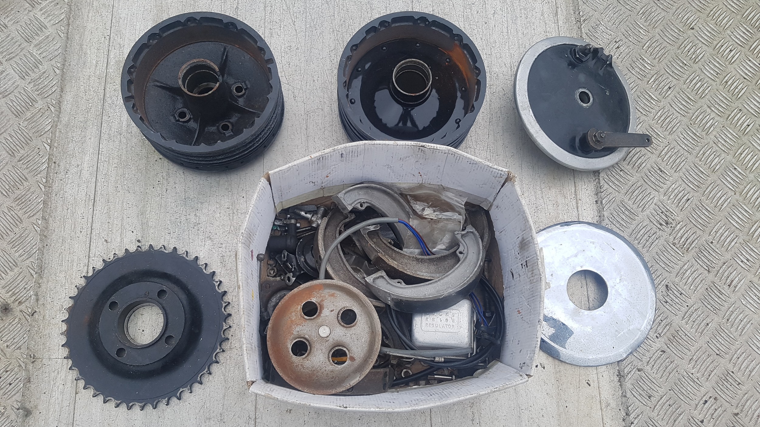 Box of BSA A10 spares including wheel hubs and brake parts