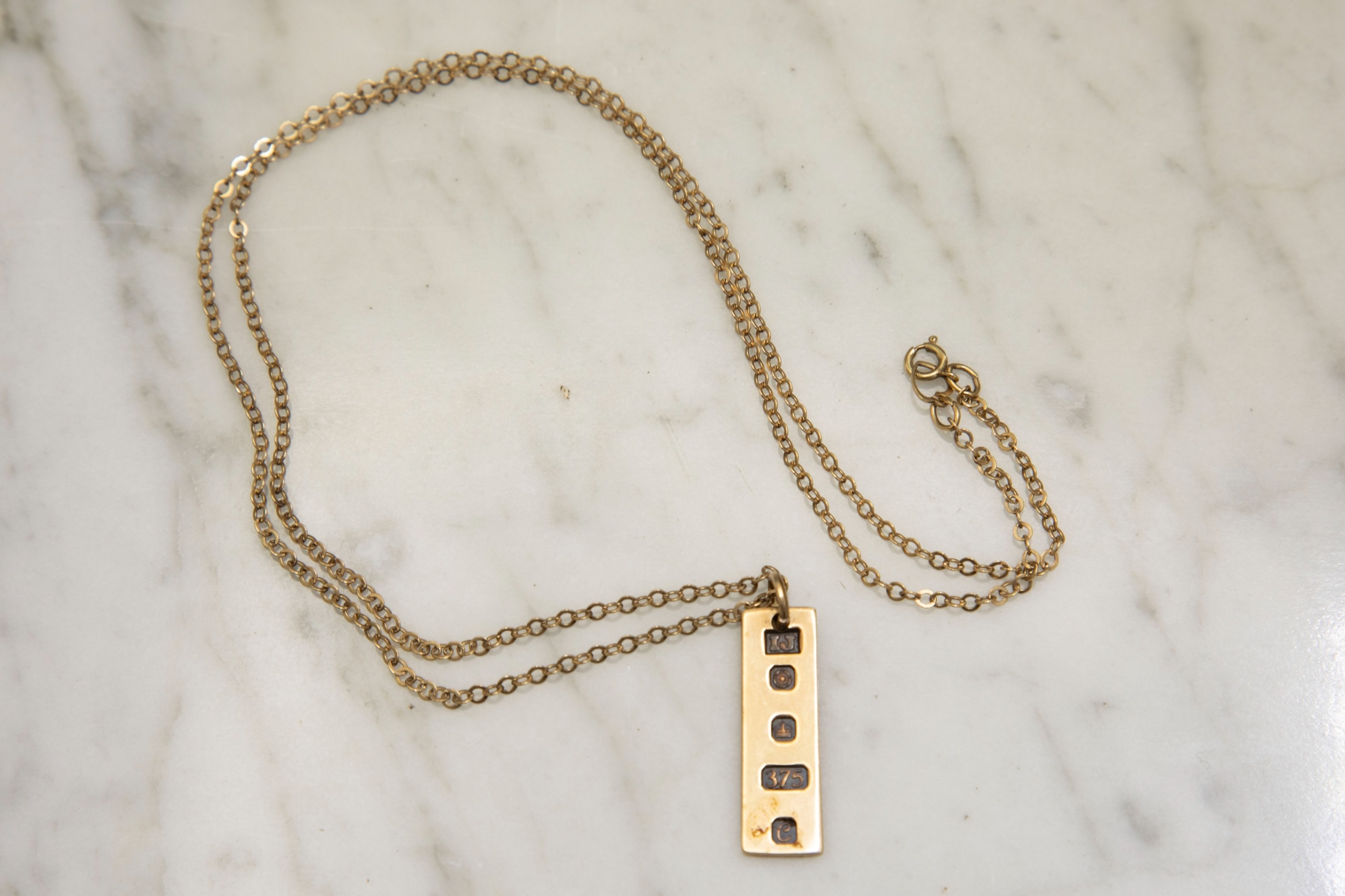 A 9ct gold 'ingot' pendant and chain, the ingot with display hallmarks ...