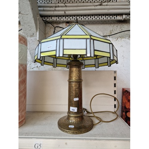 An Eastern brass table lamp with Art Deco style leaded glass shade.