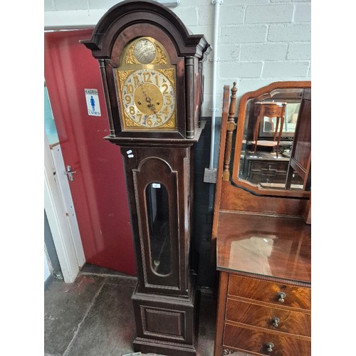 Two mahogany longcase clocks with brass dials.