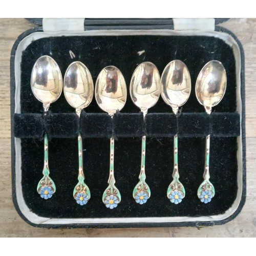A cased set of hallmarked silver teaspoons with enamel flower finials.