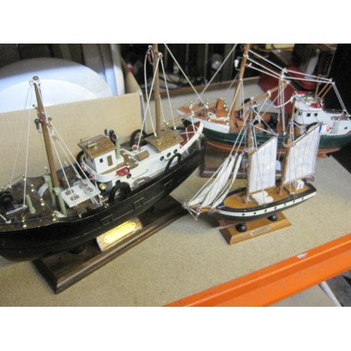A pair of plinth mounted model trawlers and a plinth mounted Mistral yacht