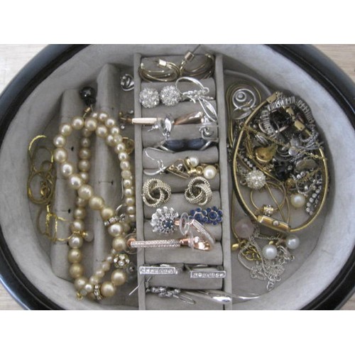 A vintage circular jewellery box containing mainly costume earrings ...