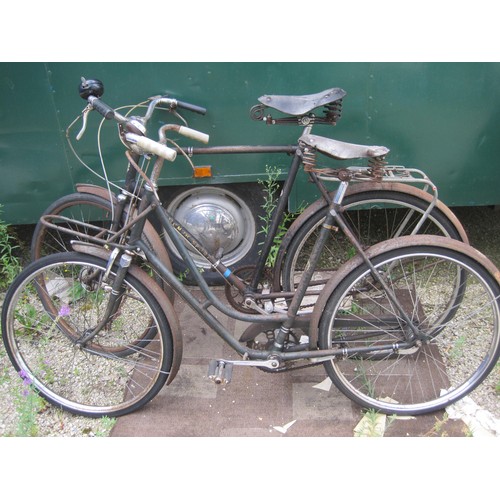 A pair of vintage push bikes - one a Triumph, the other a BSA