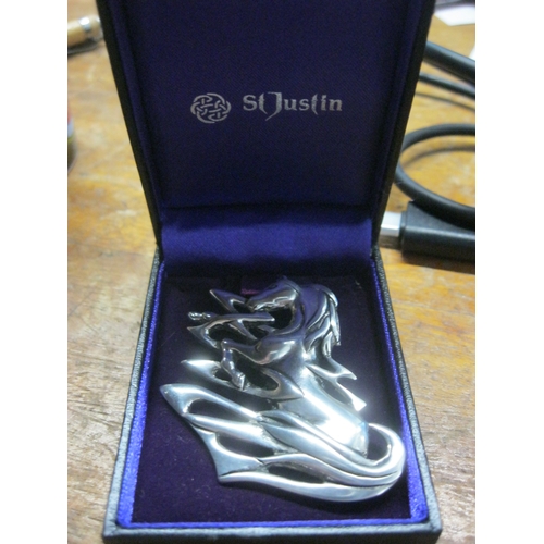 A St Justin brooch, cased, of a stylised horse, in white metal