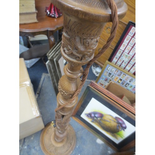 An intricately carved wooden standard lamp base, of Oriental origin ...