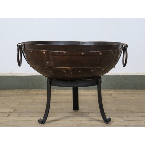 Metal 'Kadai' fire pit of riveted construction on iron stand ...