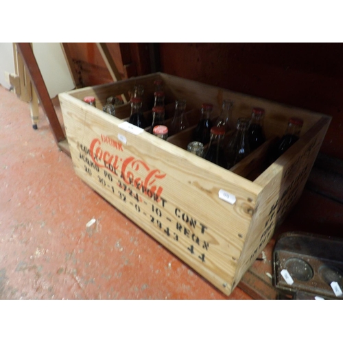 A Chrysler Coca Cola bottle box containing various bottles of Coca Cola