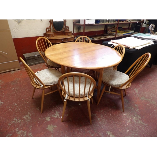 A mid century Ercol twin flap gateleg dining table together with four ...