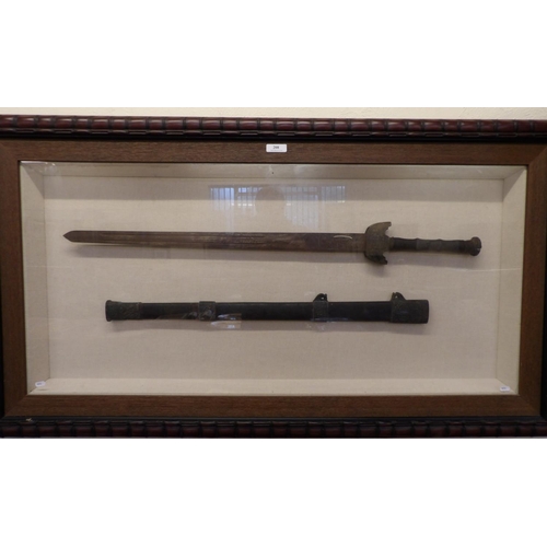 A substantial oriental sword and scabbard mounted within a simulated ...