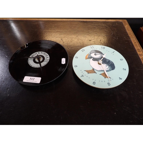 Two novelty wall clocks: a rock and roll clock and a puffin clock