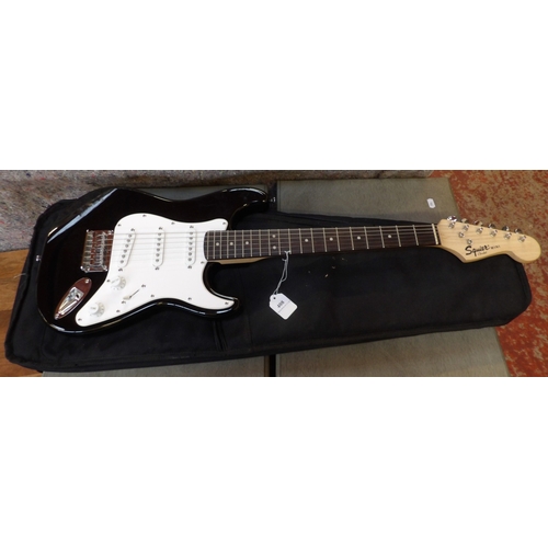 A Squier by Fender mini electric guitar and case
