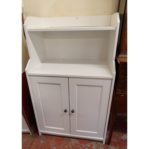 A white finished side cabinet fitted a gallery above