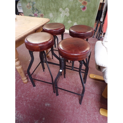 A set of four adjustable breakfast stools the seats upholstered in ...