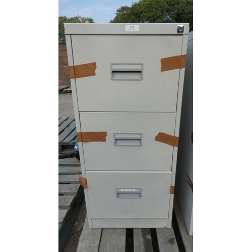 A metallic three drawer filing cabinet