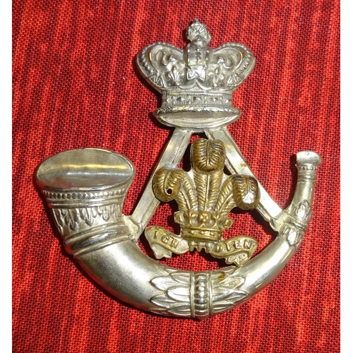 A white metal crowned strung bugle pouch badge, P.O.W. feathers between ...