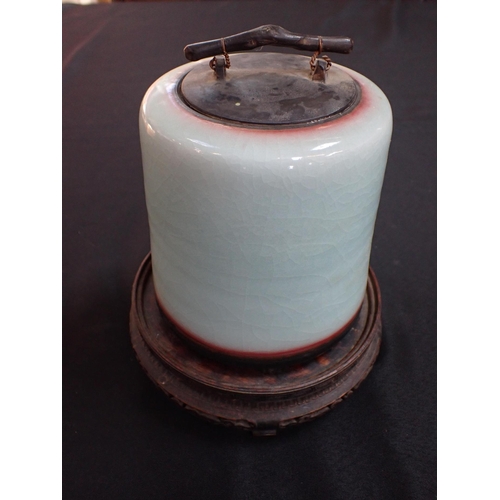 A PALE BLUE GLAZED PORCELAIN JAR the cover with twig handle, with ...