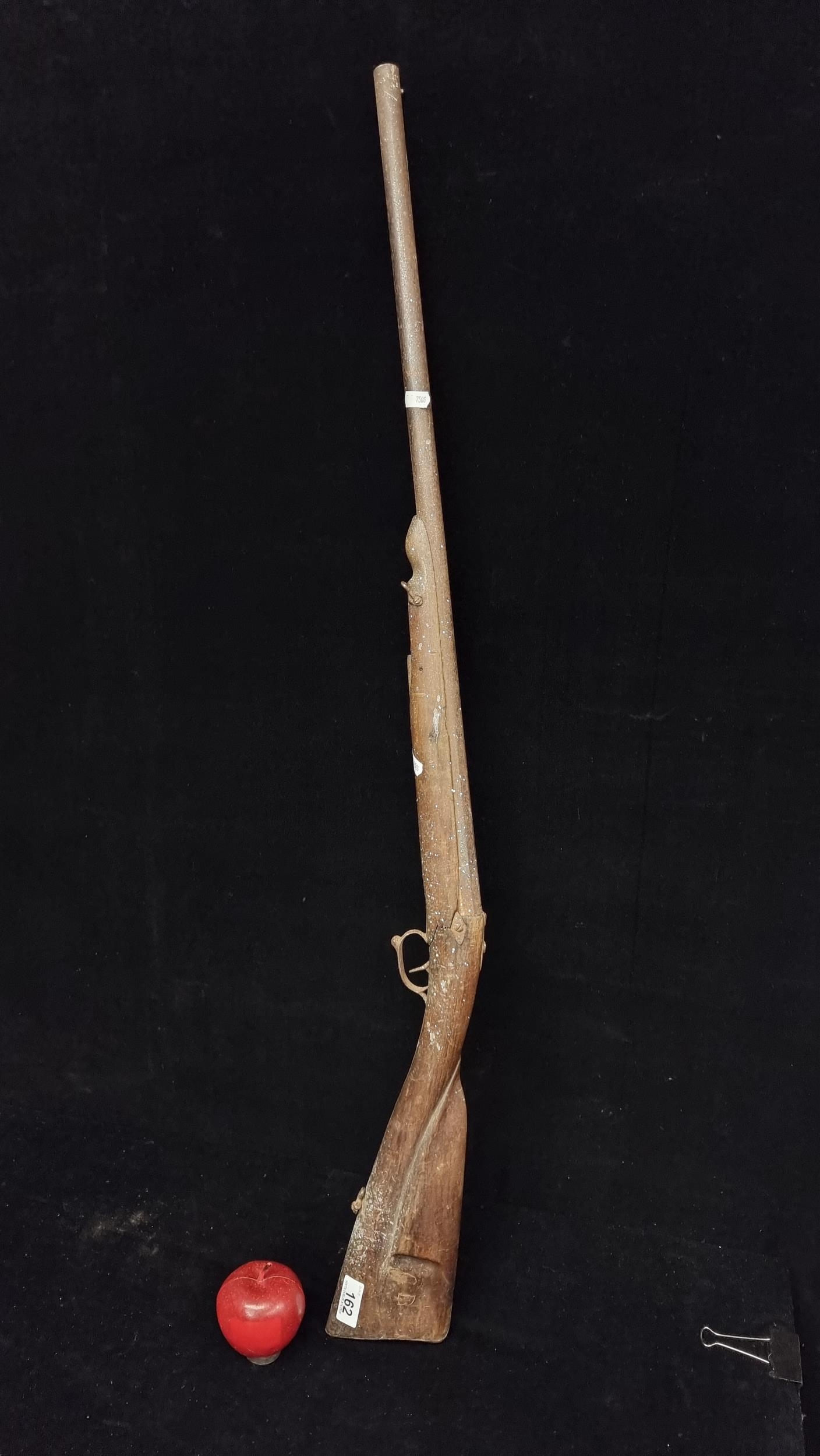 A heavy antique rifle, with wooden stock and intact trigger ...