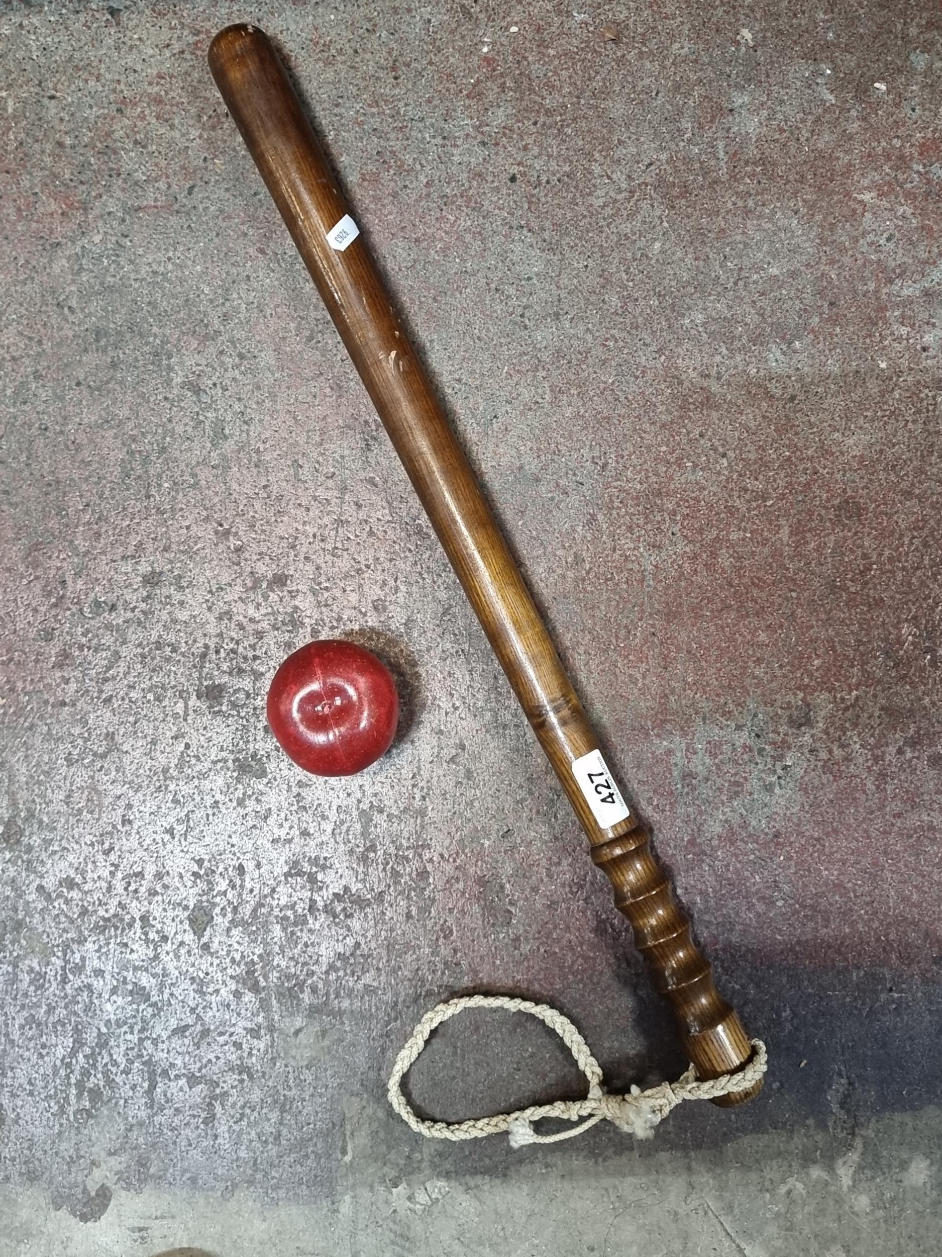 A very long vintage wooden truncheon with rope loop and form-fitting ...