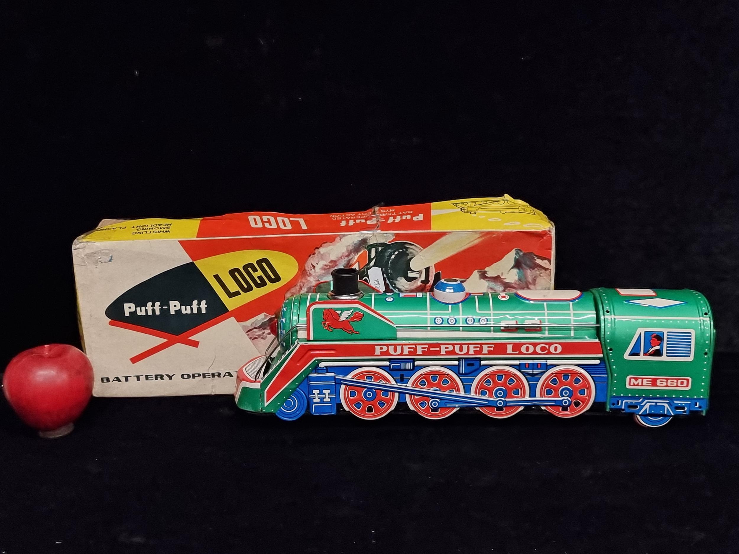 A super vintage "Puff-Puff Loco" battery operated tin model train. A ...