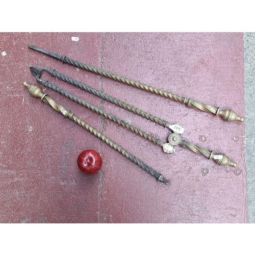 A set of heavy antique brass fire irons with twisted stem.